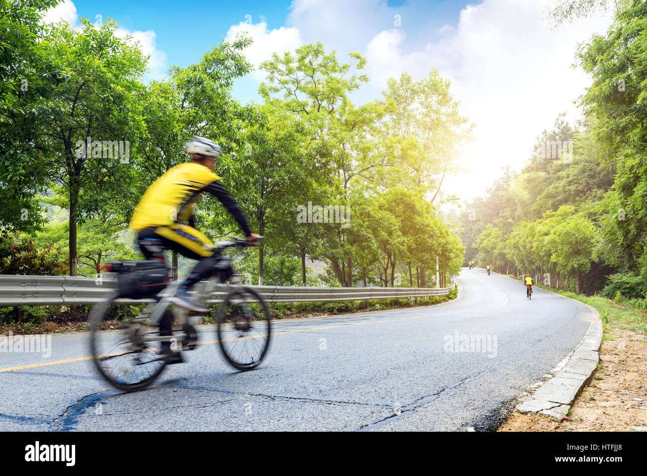Cyclist riding a bike on an open road Stock Photo - Alamy