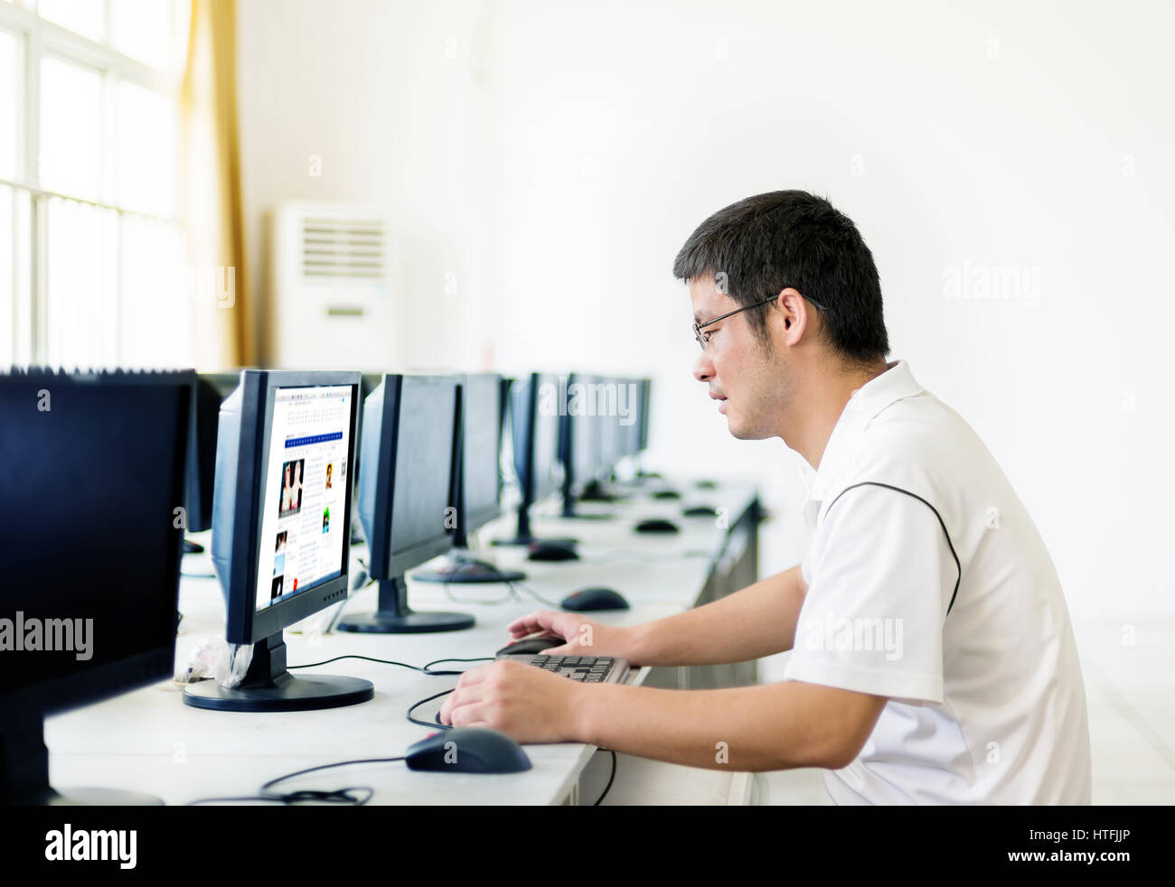 Asian man in front of the computer work Stock Photo - Alamy
