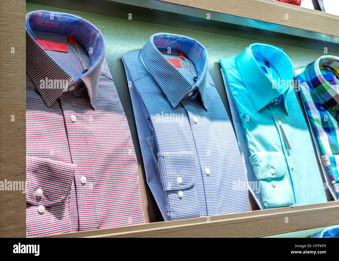 Showcase with many colorful shirts on shelfs Stock Photo - Alamy