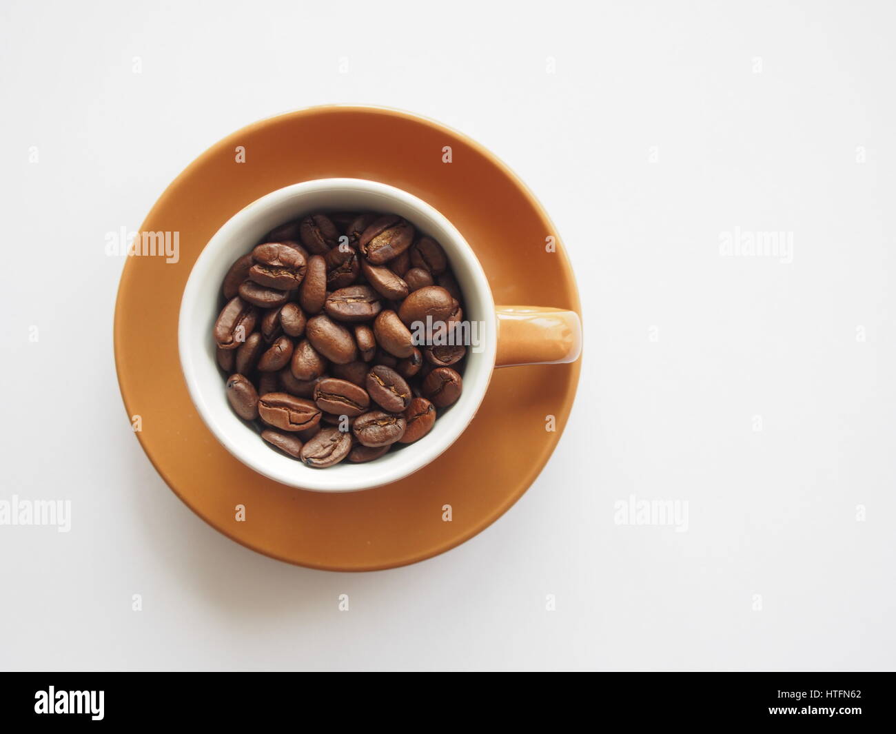 Coffee cup full of coffee beans on white background Stock Photo - Alamy