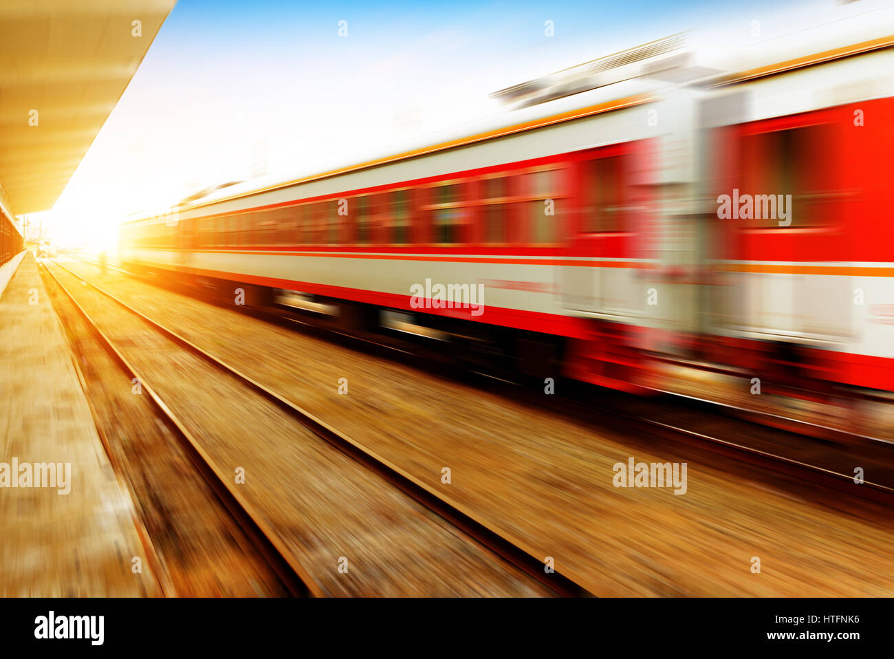 Train passing by in orange sunset Stock Photo - Alamy