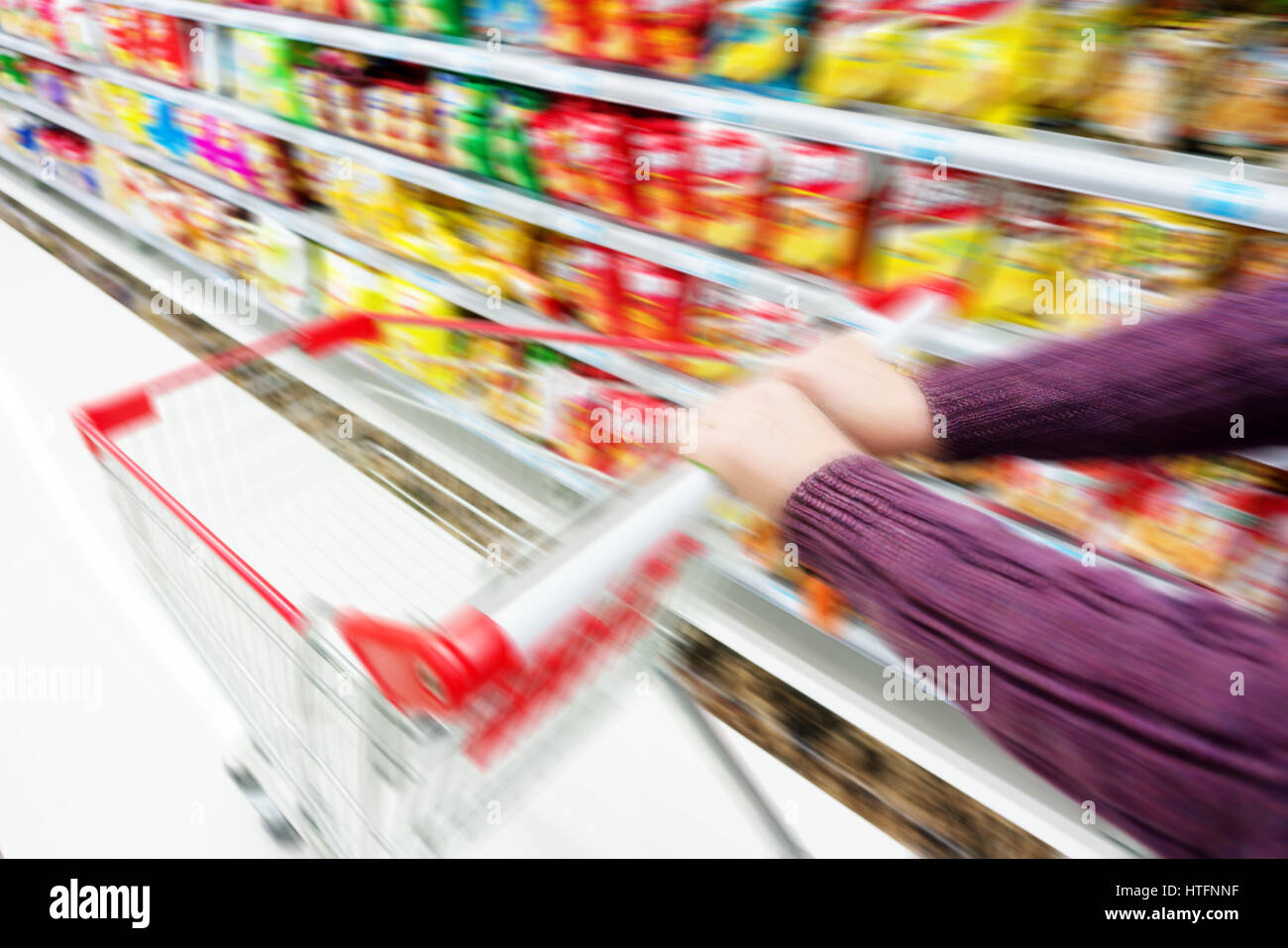 Lady pushing a shopping cart in the supermarket Stock Photo - Alamy