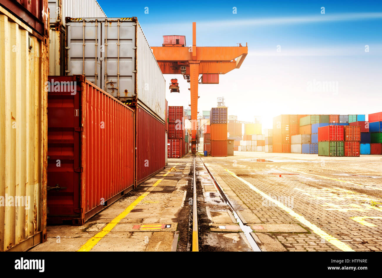 The container terminal at dusk, a large crane work Stock Photo - Alamy