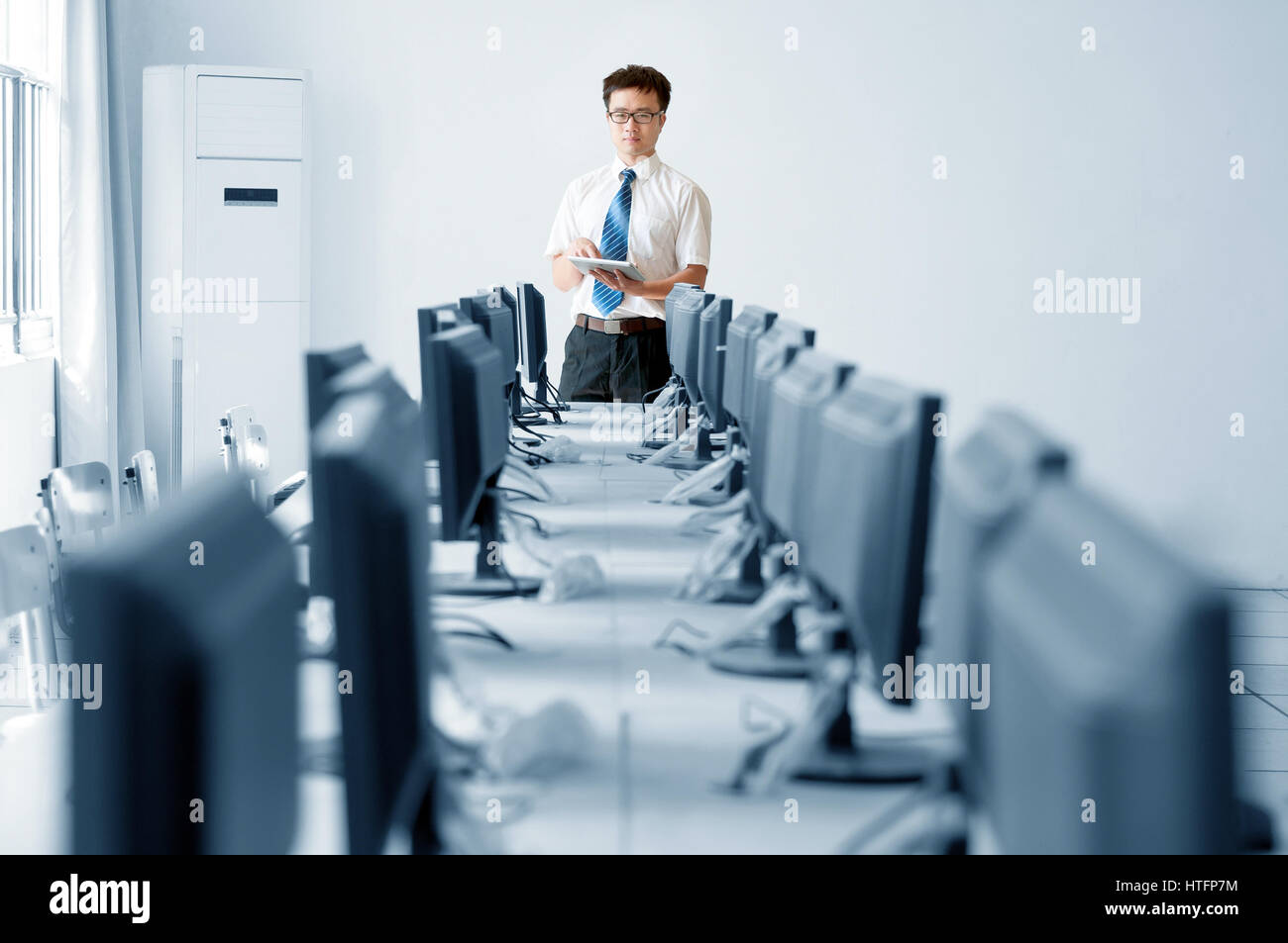 Asian man working in the computer room Stock Photo - Alamy