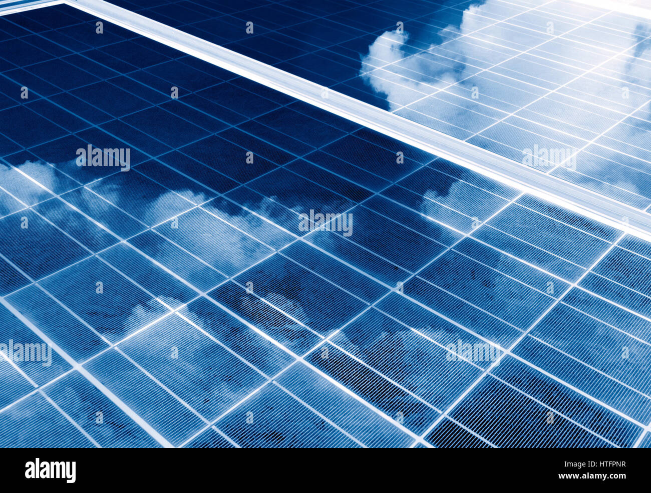 Array of solar panels with blue sky reflection Stock Photo - Alamy