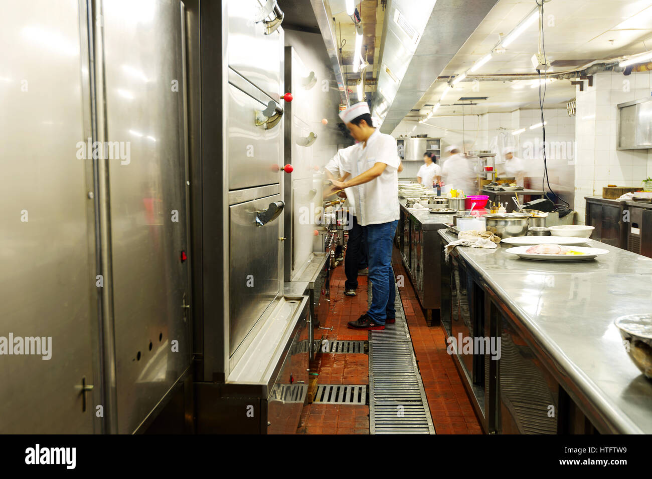 Crowded kitchen, a narrow aisle, working chef Stock Photo - Alamy