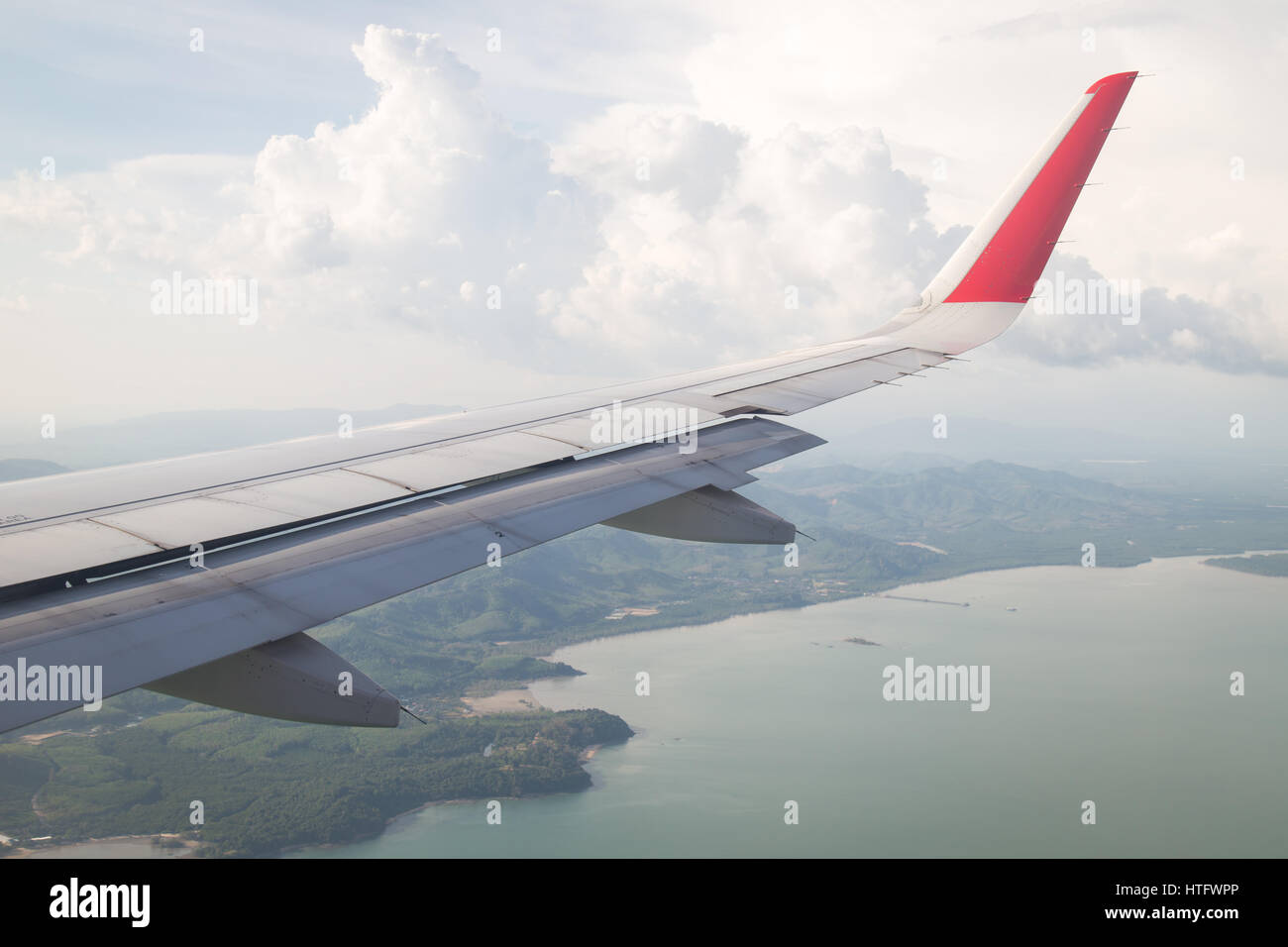 Wing of an airplane flying above the ocean and many island Stock Photo ...