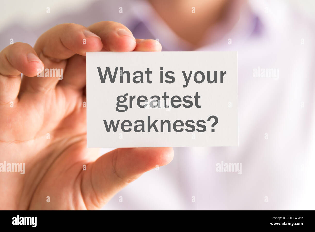 Closeup on businessman holding a card with WHAT IS YOUR GREATEST ...