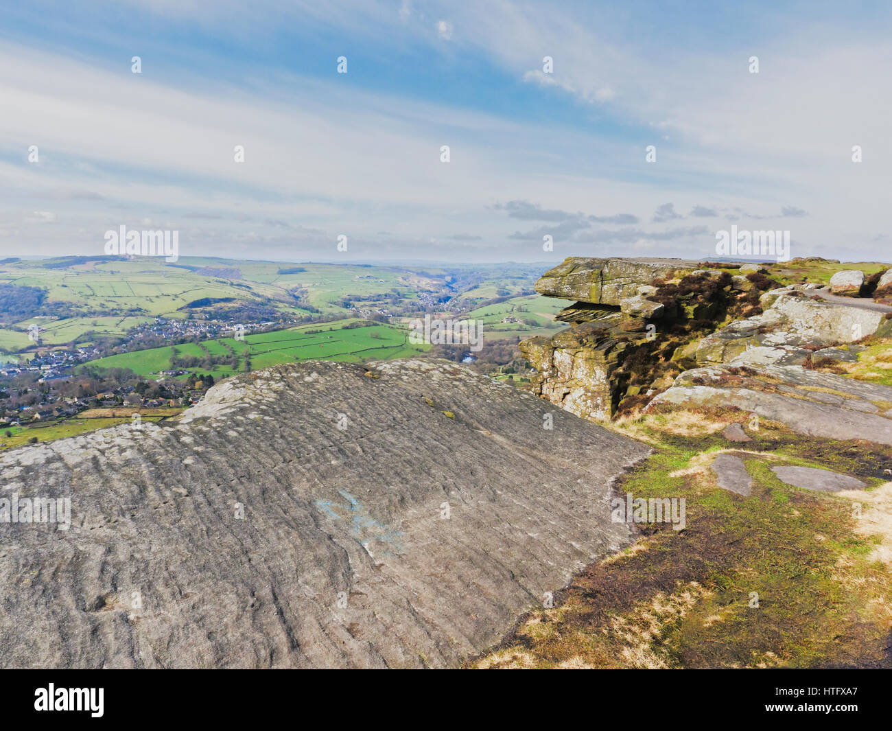 Out across the protruding slabs of gritstone rock over the Derbyshire ...