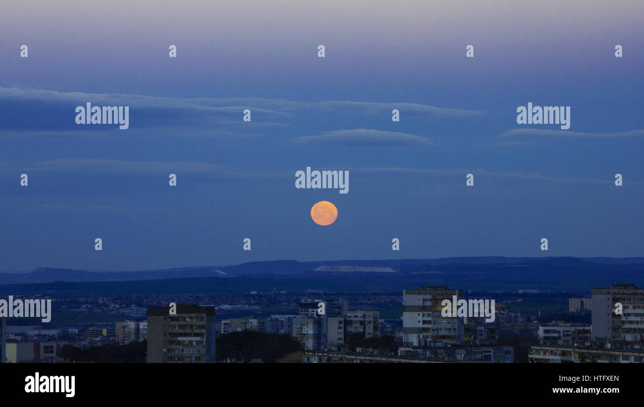 Full moon over city Stock Photo - Alamy