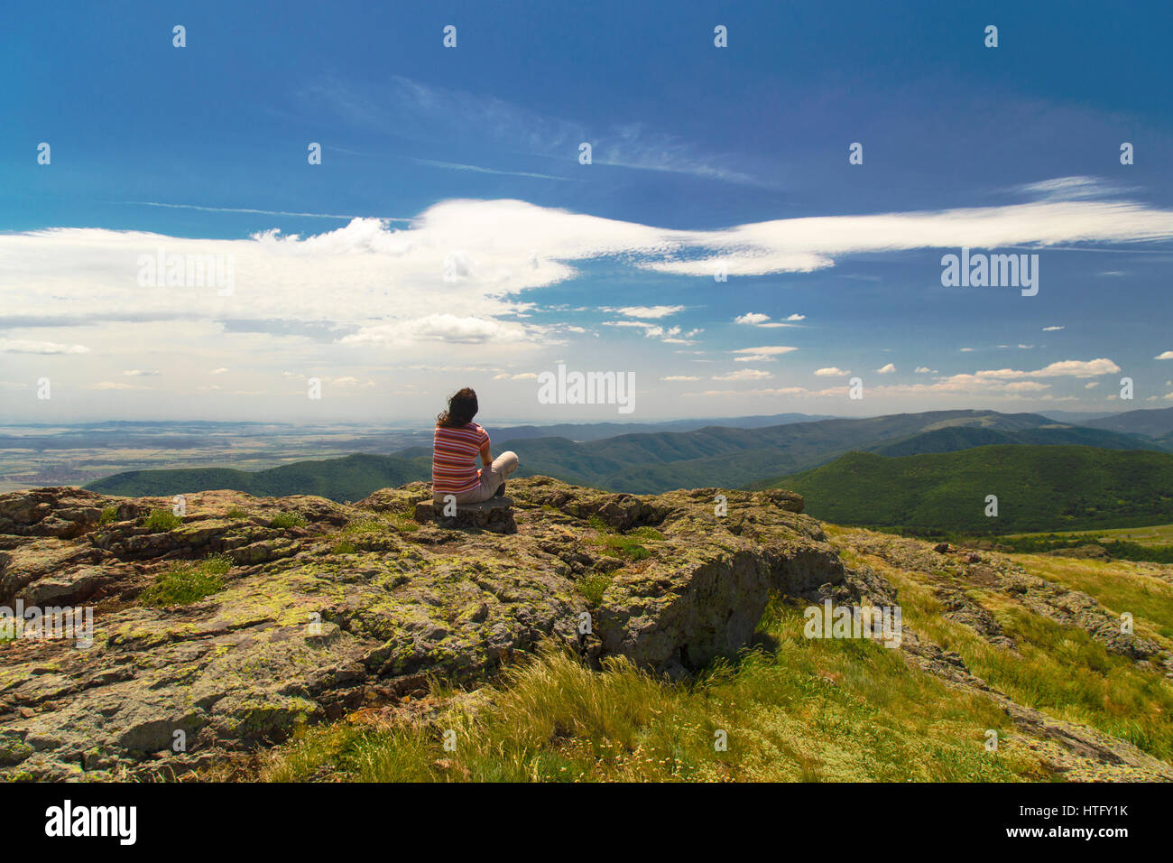 Young woman relaxing on the rocks in high mountain Stock Photo - Alamy