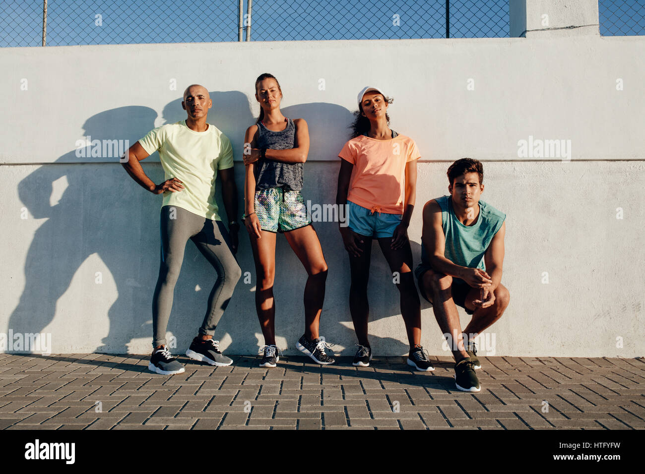 Full length shot of young people standing together by a wall after ...