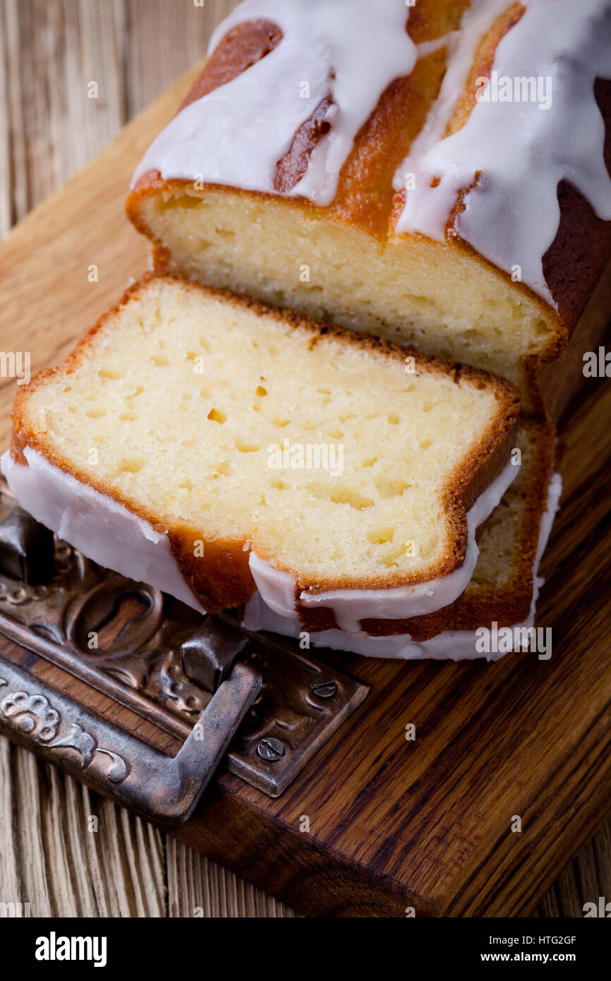 Homemade glazed lemon pound cake on rustic wooden table, sliced and ...