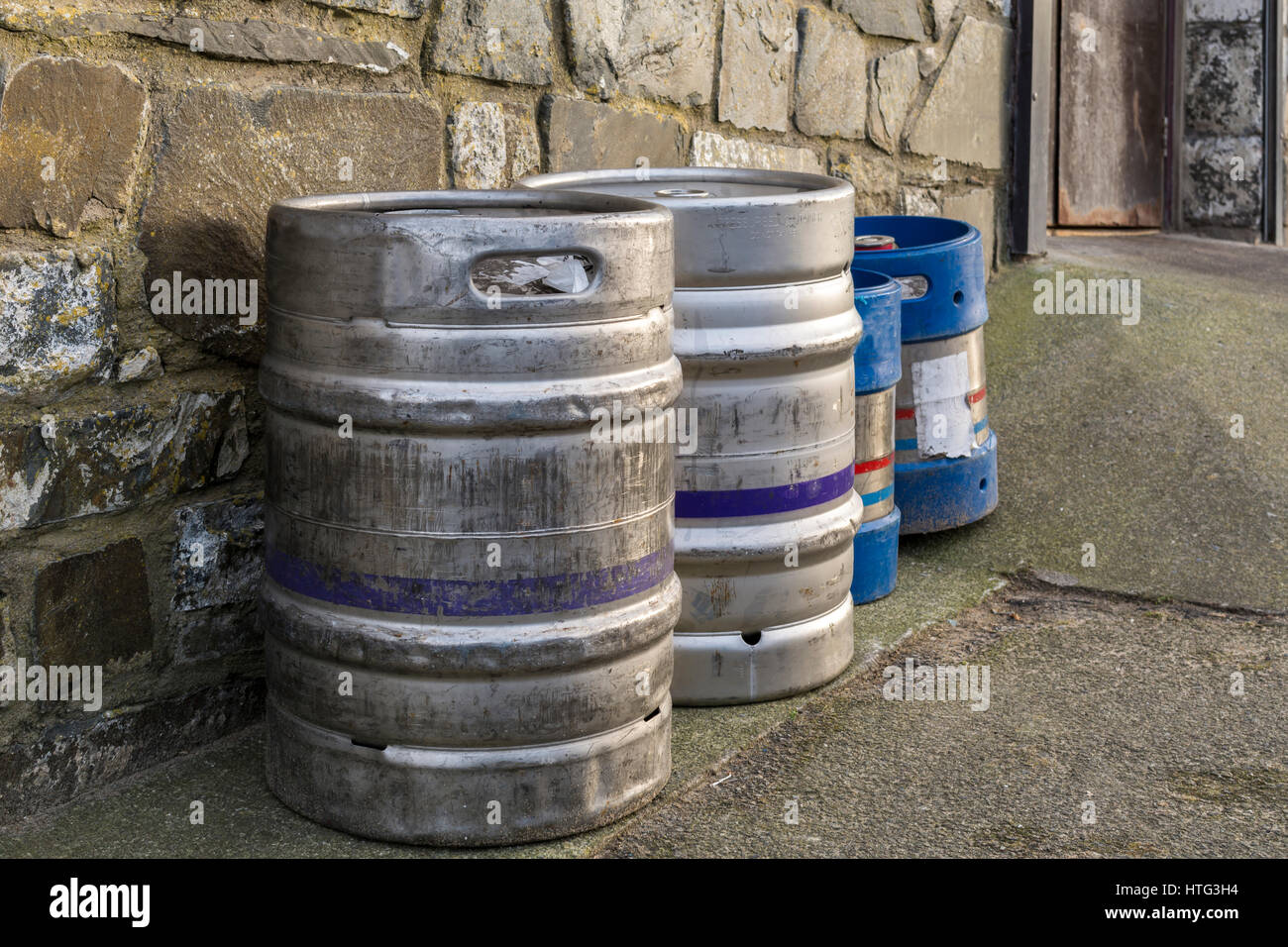 Metal beer kegs, stacked against the outside of a pub, bar wall in the ...