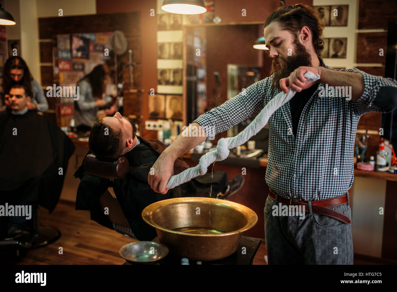 Barber squeeze towel in a copper basin at barbershop. Hairdressing ...