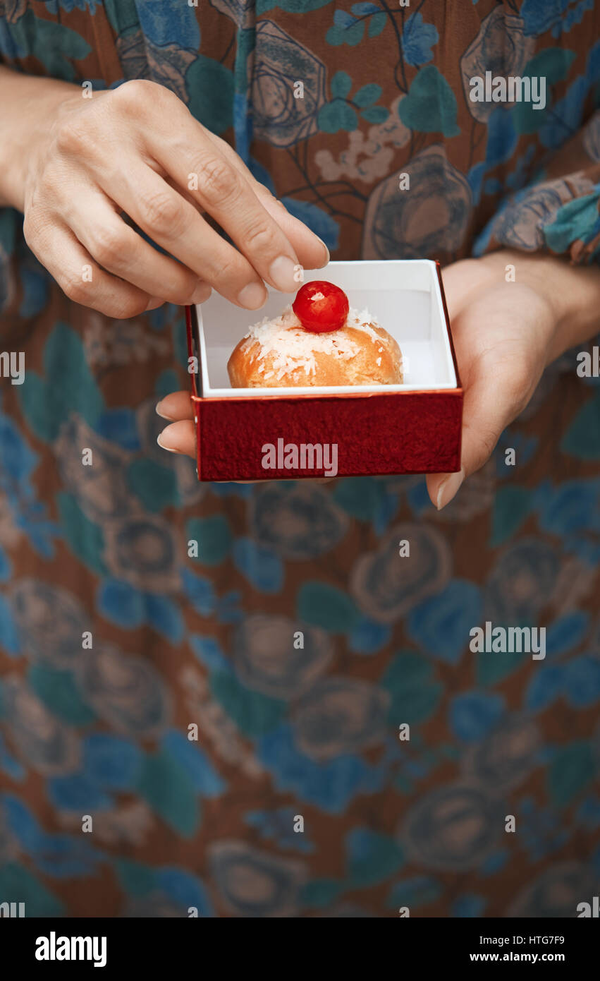 Woman holding eclair in the box. Vertical photo Stock Photo - Alamy