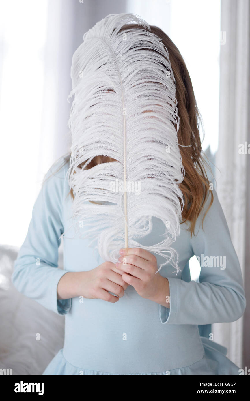 Cute little girl holding a white feathers on white background Stock ...