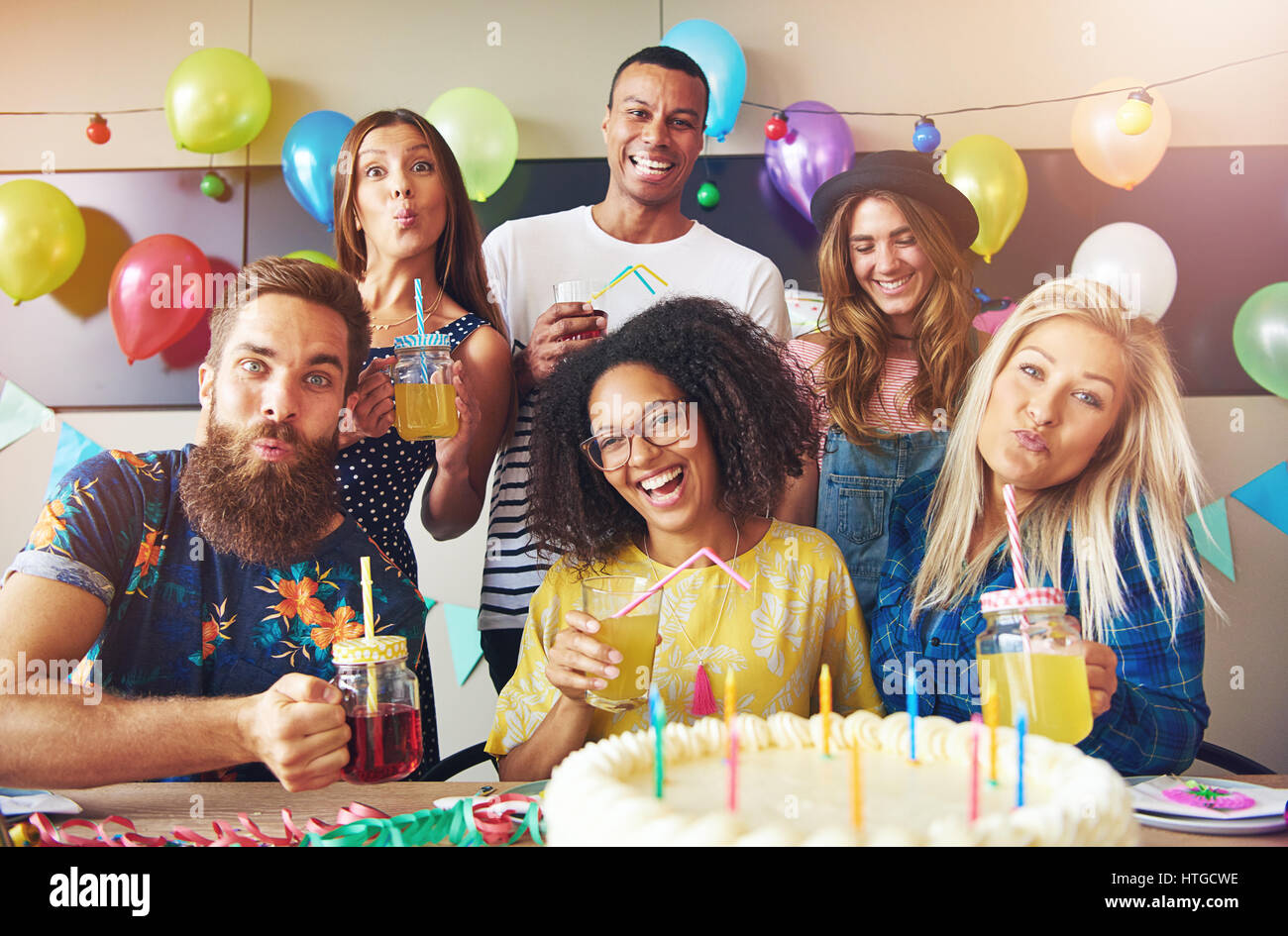 Six diverse group of friends at party sitting at table in front of ...