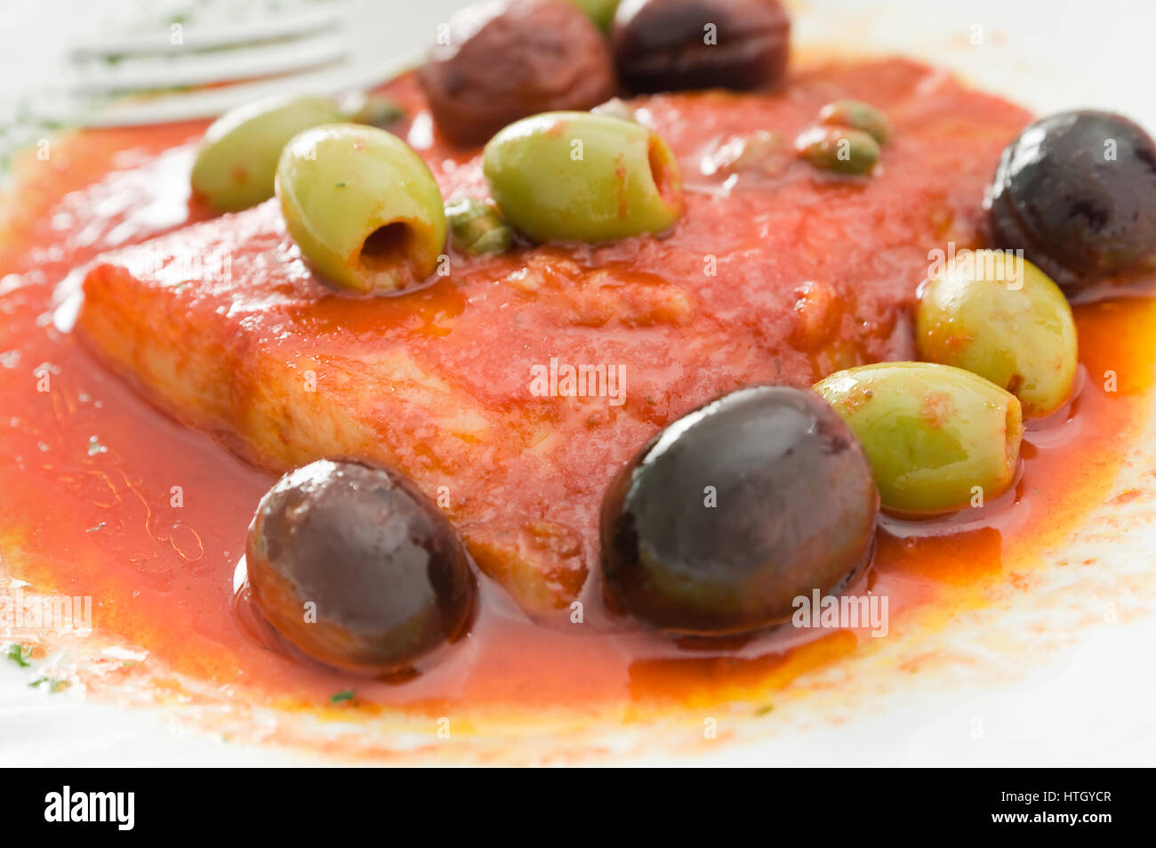 Fish with olives in tomato sauce Stock Photo - Alamy