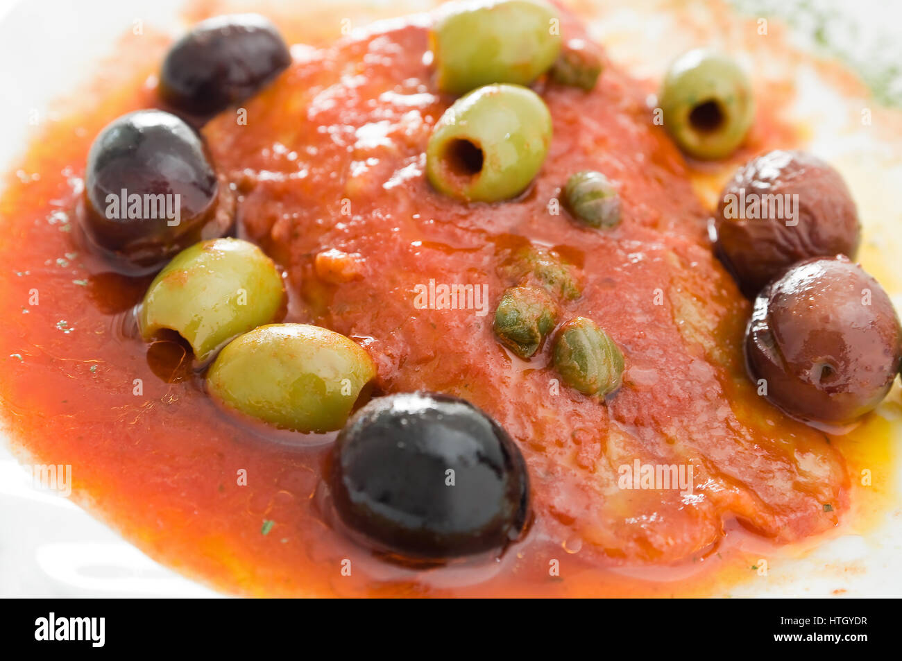 Fish with olives in tomato sauce Stock Photo - Alamy