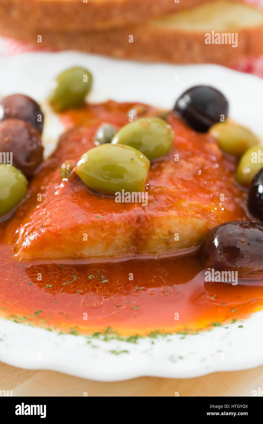 Fish with olives in tomato sauce Stock Photo - Alamy