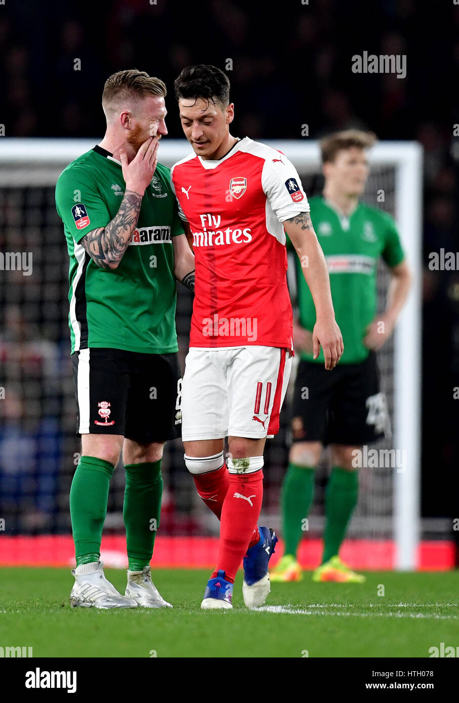 Lincoln City's Alan Power shares a joke with Arsenal's Mesut Ozil ...