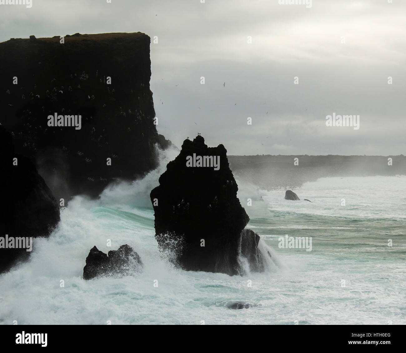 Stormy landscape of waves crashing against black cliffs at Valahnúkamöl ...