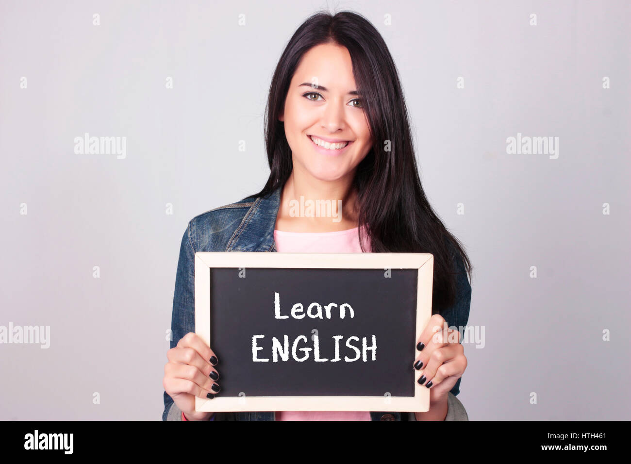 Young beautiful woman holding a chalkboard that says Learn English ...