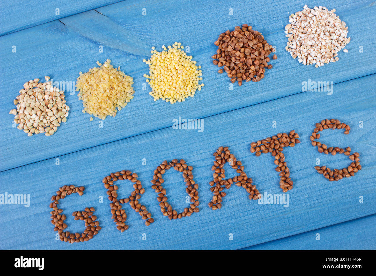 Inscription groats and heap of various groats on blue boards, concept ...