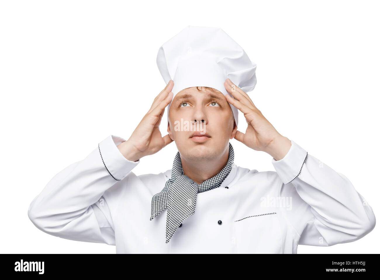 young chef adjusts his hat on his head on a white background Stock ...
