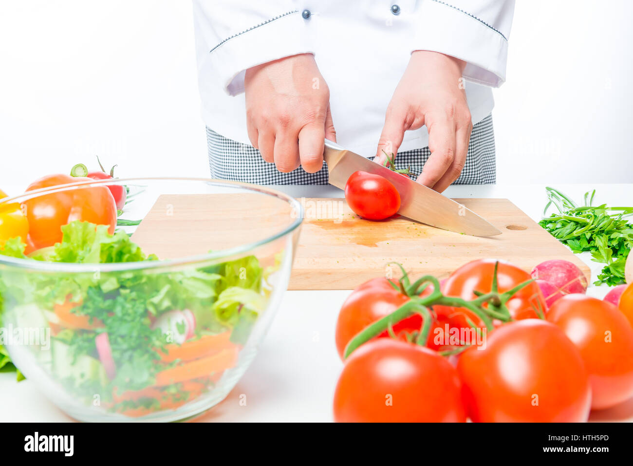 Chef in uniform cuts the organic vegetables in a glass bowl Stock Photo ...