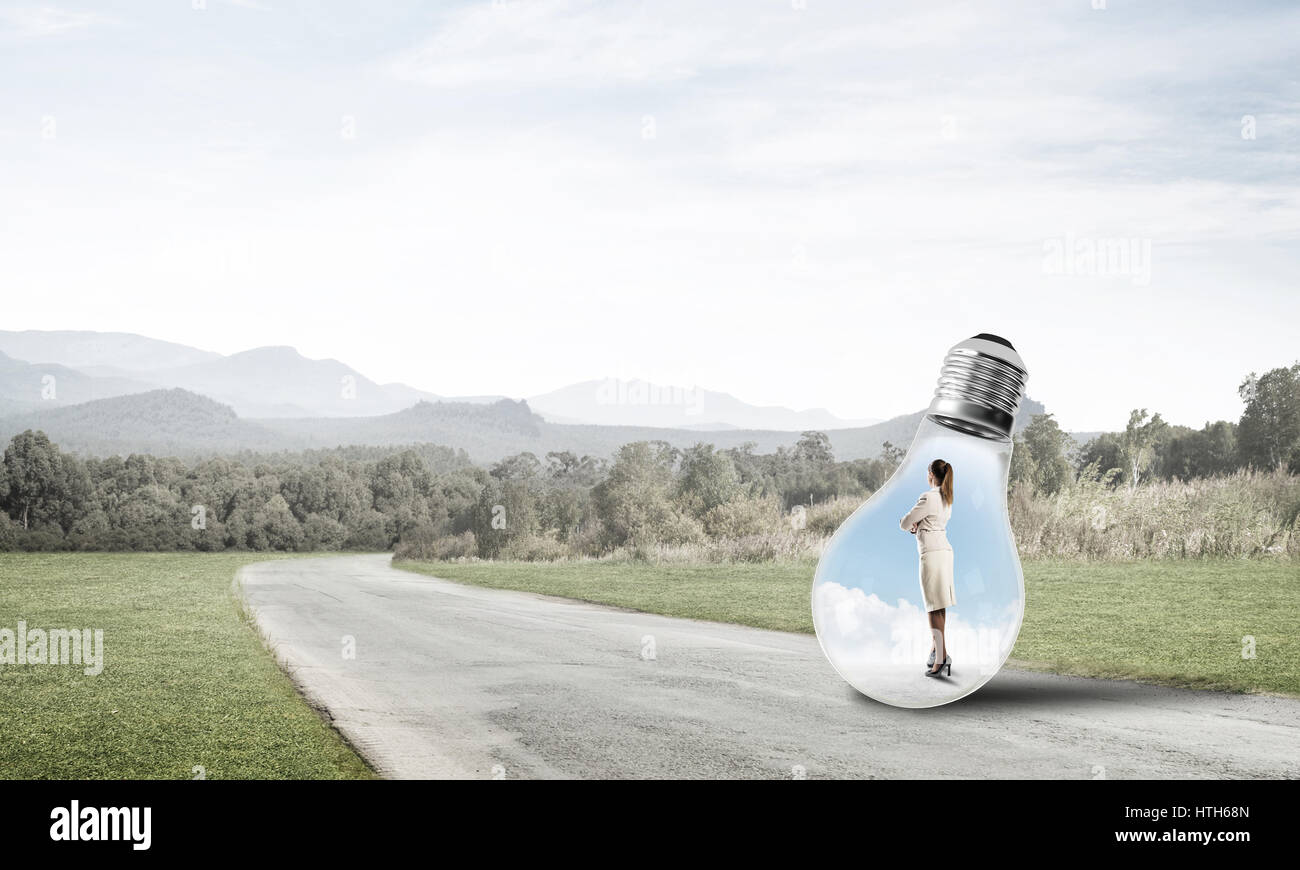 Young businesswoman trapped inside of light bulb on asphalt road Stock ...