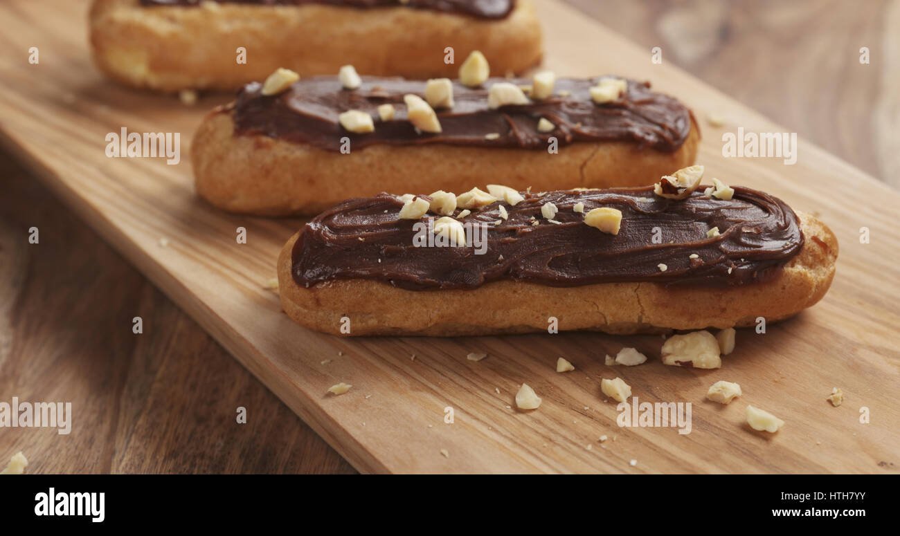 eclairs with hazelnuts on wood board, 4k photo Stock Photo - Alamy