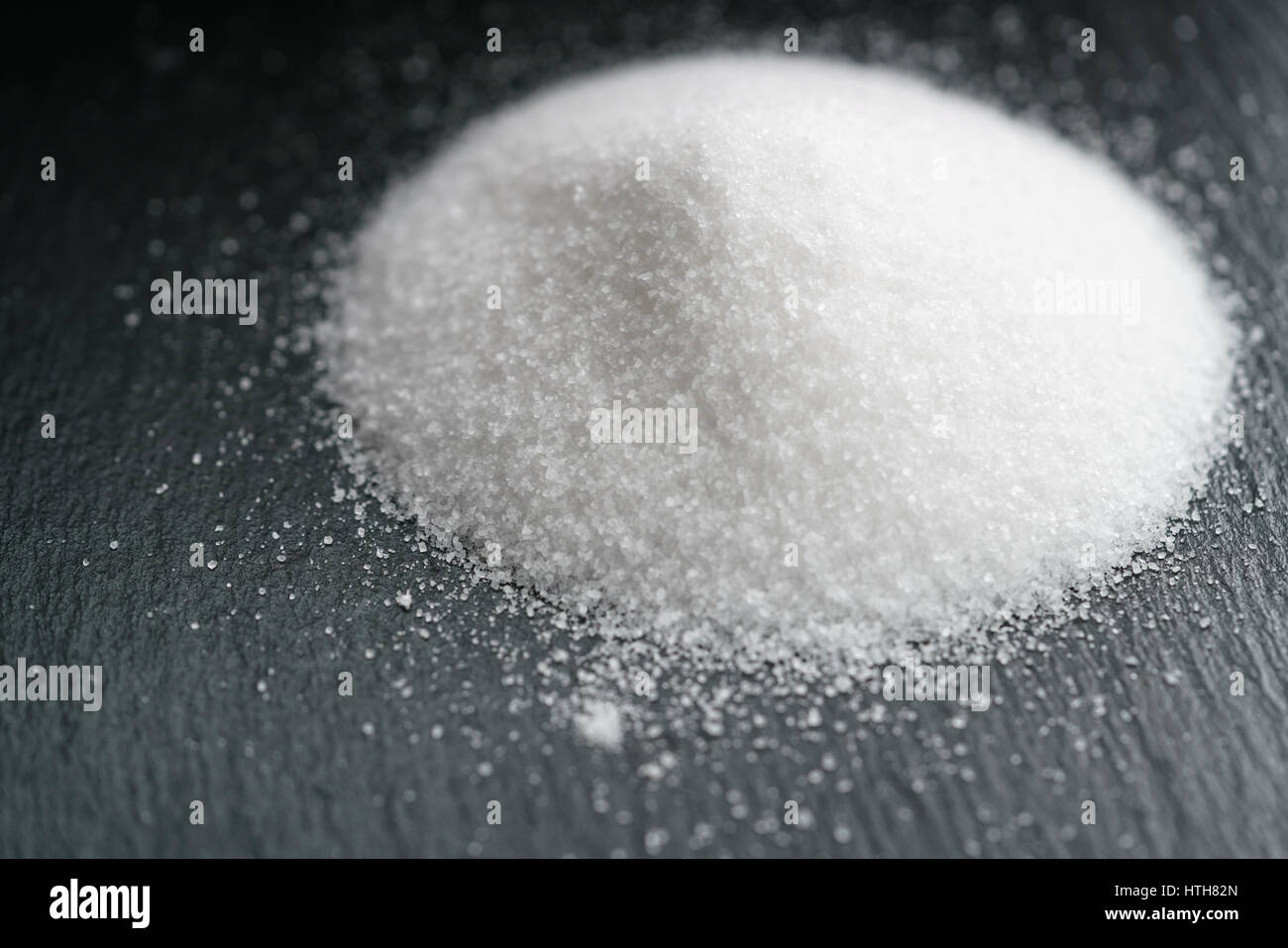 heap of extra small salt on black slate background, shallow focus Stock ...