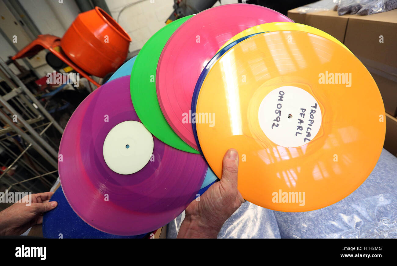 A press room operative looks through a selection of coloured vinyl ...