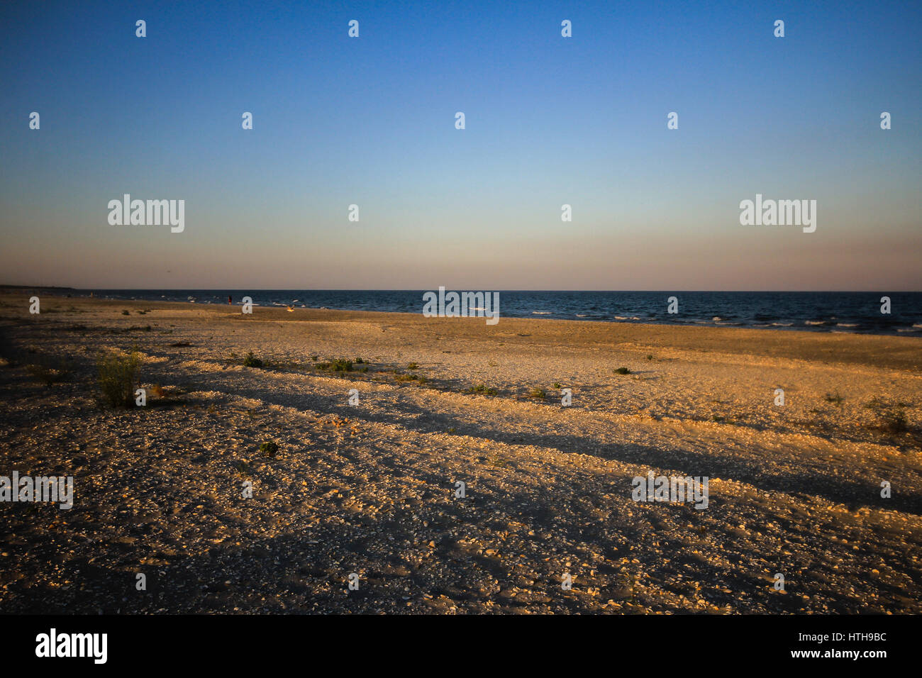 Empty beach at sunset Stock Photo - Alamy