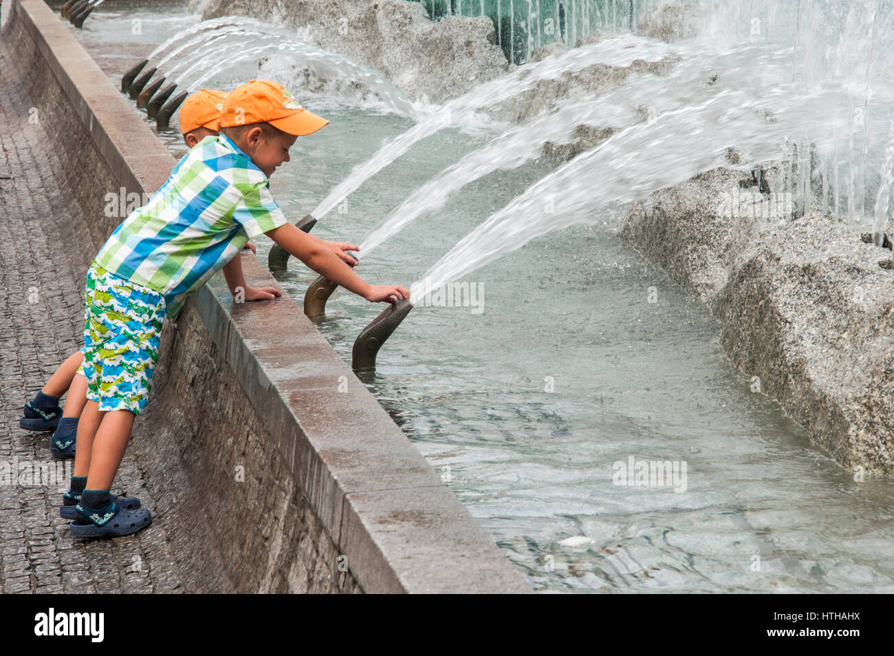 Two boys playing with water jets at Rynek Fountain, 1996, designed by ...