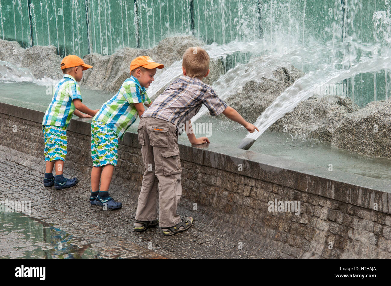 Three boys playing with water jets at Rynek Fountain, 1996, designed by ...