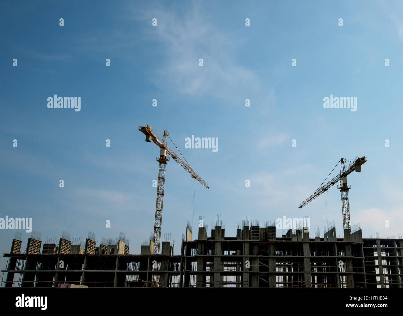 two tower crane working on building a house Stock Photo - Alamy