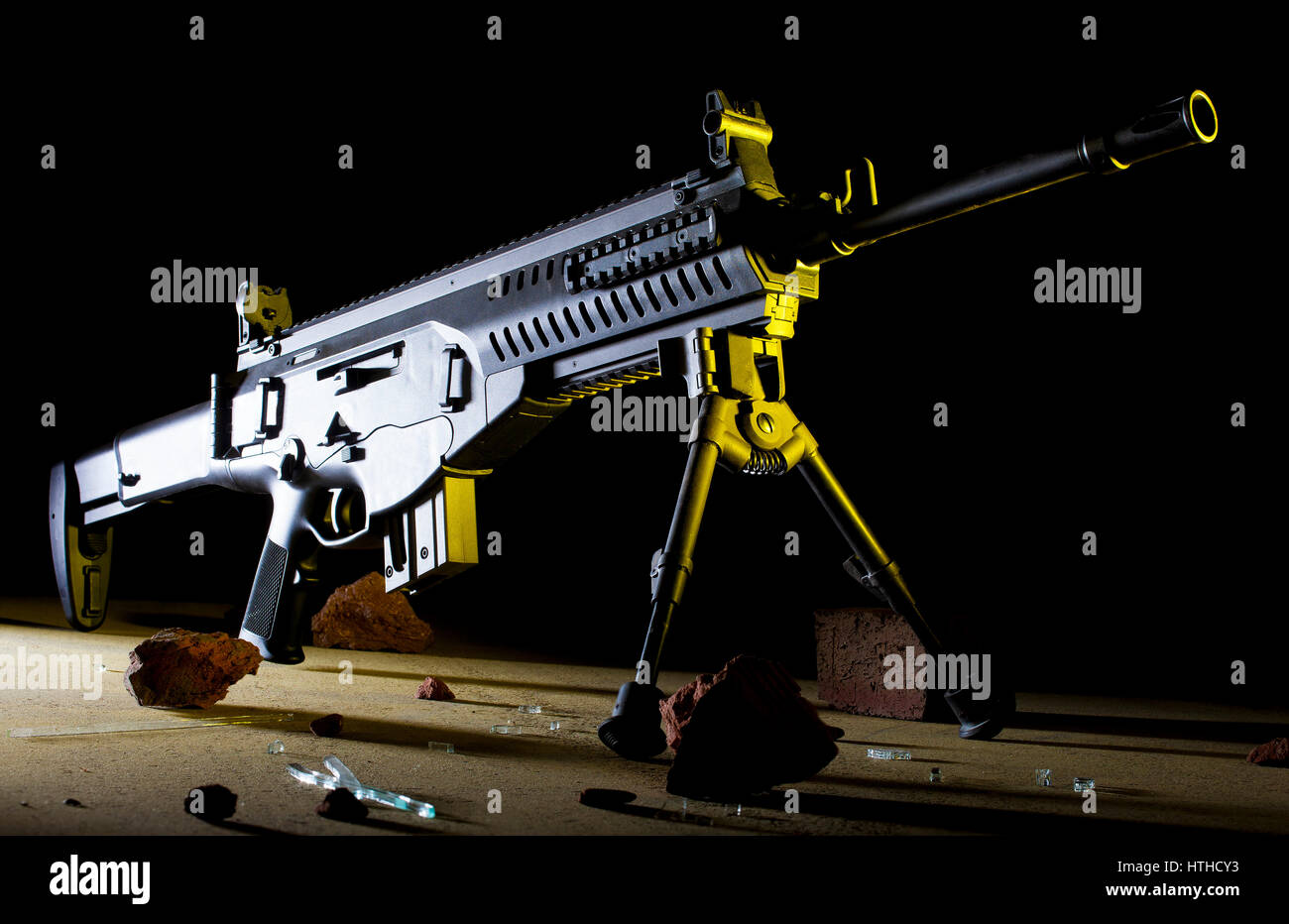 Yellow side lighting on an assault rifle with a dark background Stock ...