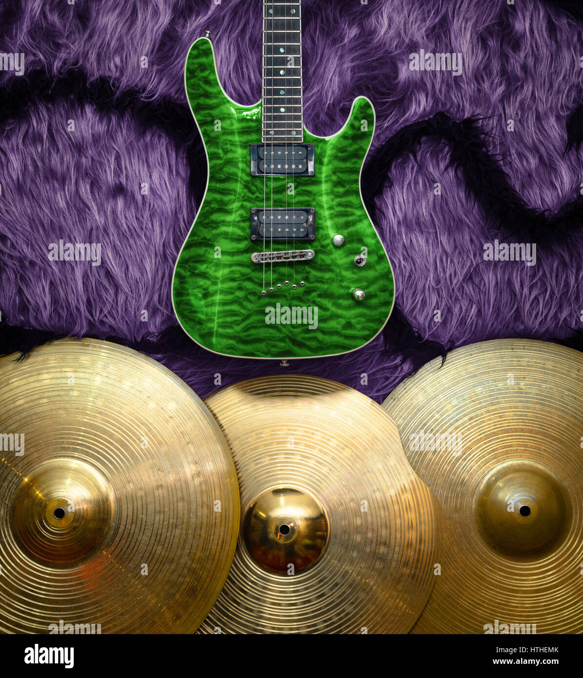 Green electric guitar with three cymbals on faux fur wall. Musical ...