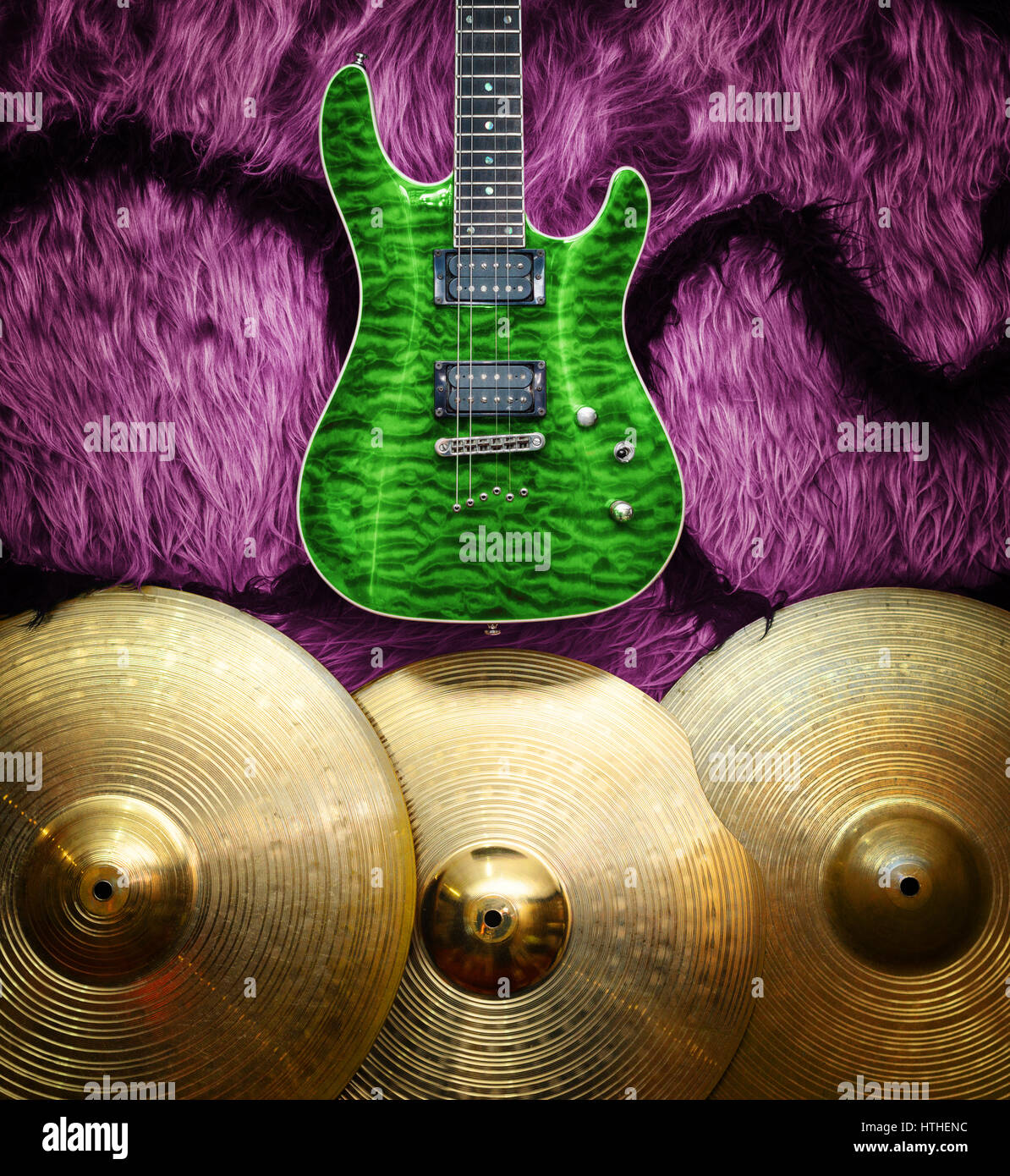 Green electric guitar with three cymbals on faux fur wall. Musical ...