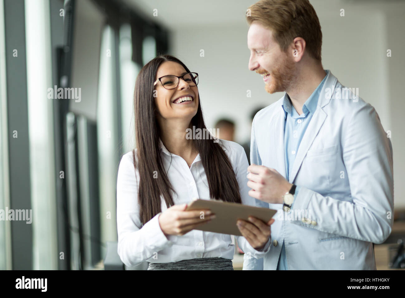 Happy business colleagues laughing together at work in office Stock ...
