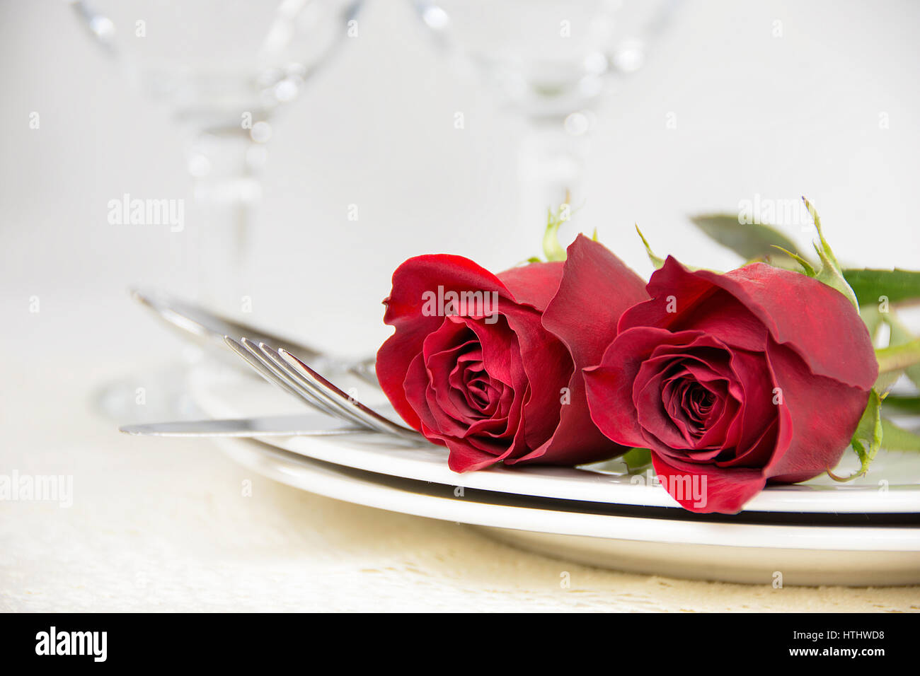 red roses on dinner plate with silverware Stock Photo - Alamy
