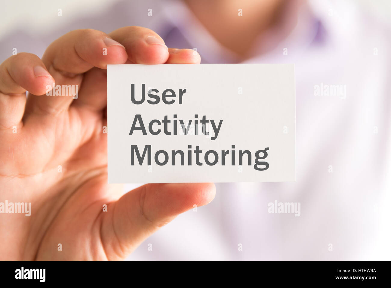 Closeup on businessman holding a card with UAM USER ACTIVITY MONITORING ...