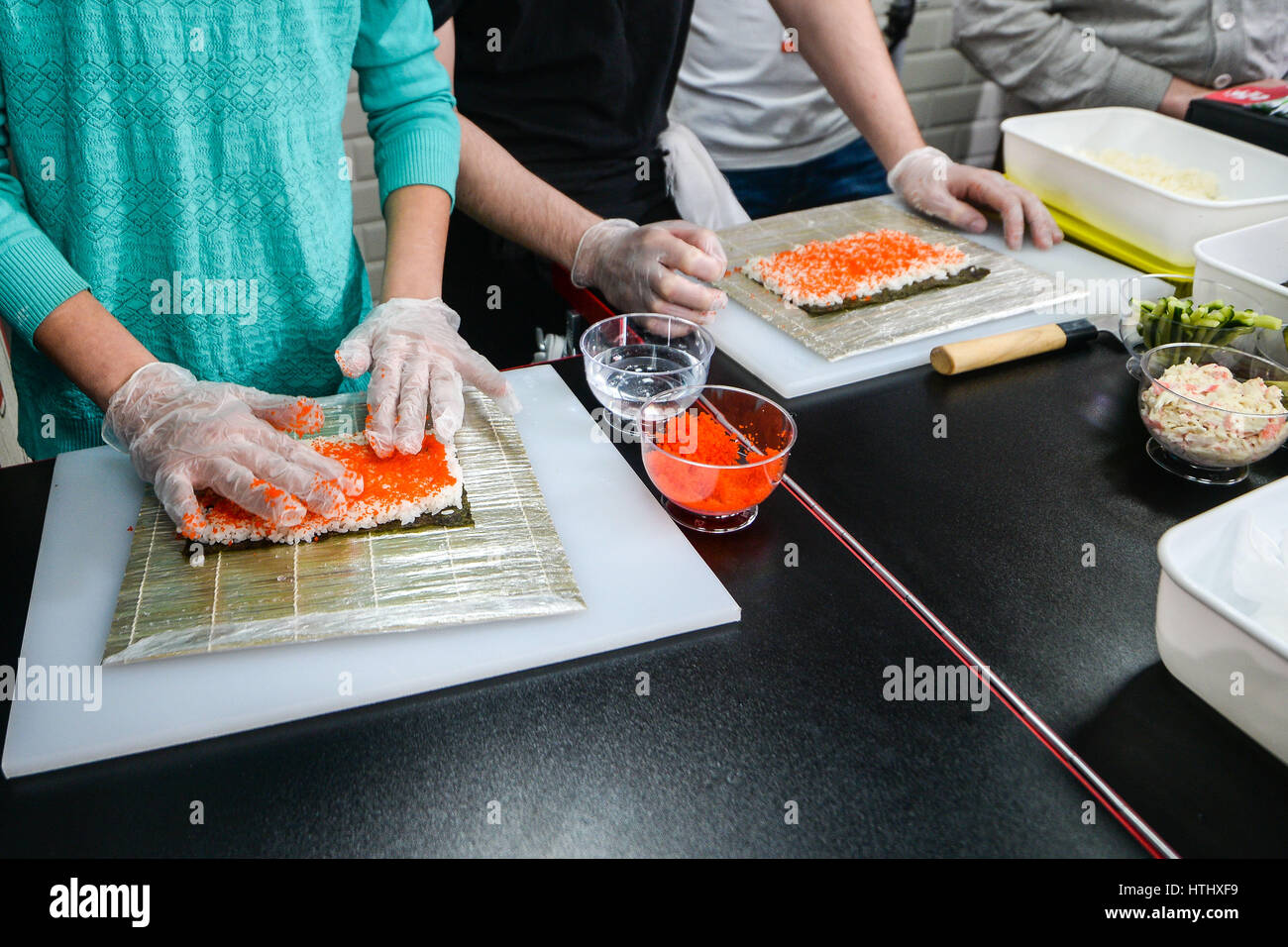 Human hands cooking sushi rolls hi-res stock photography and images - Alamy