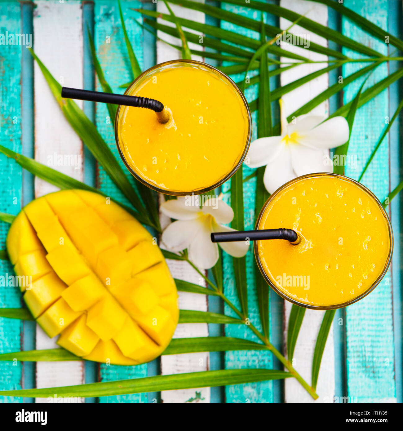 Mango smoothie, juice and fresh mango on a outdoor tropical background ...