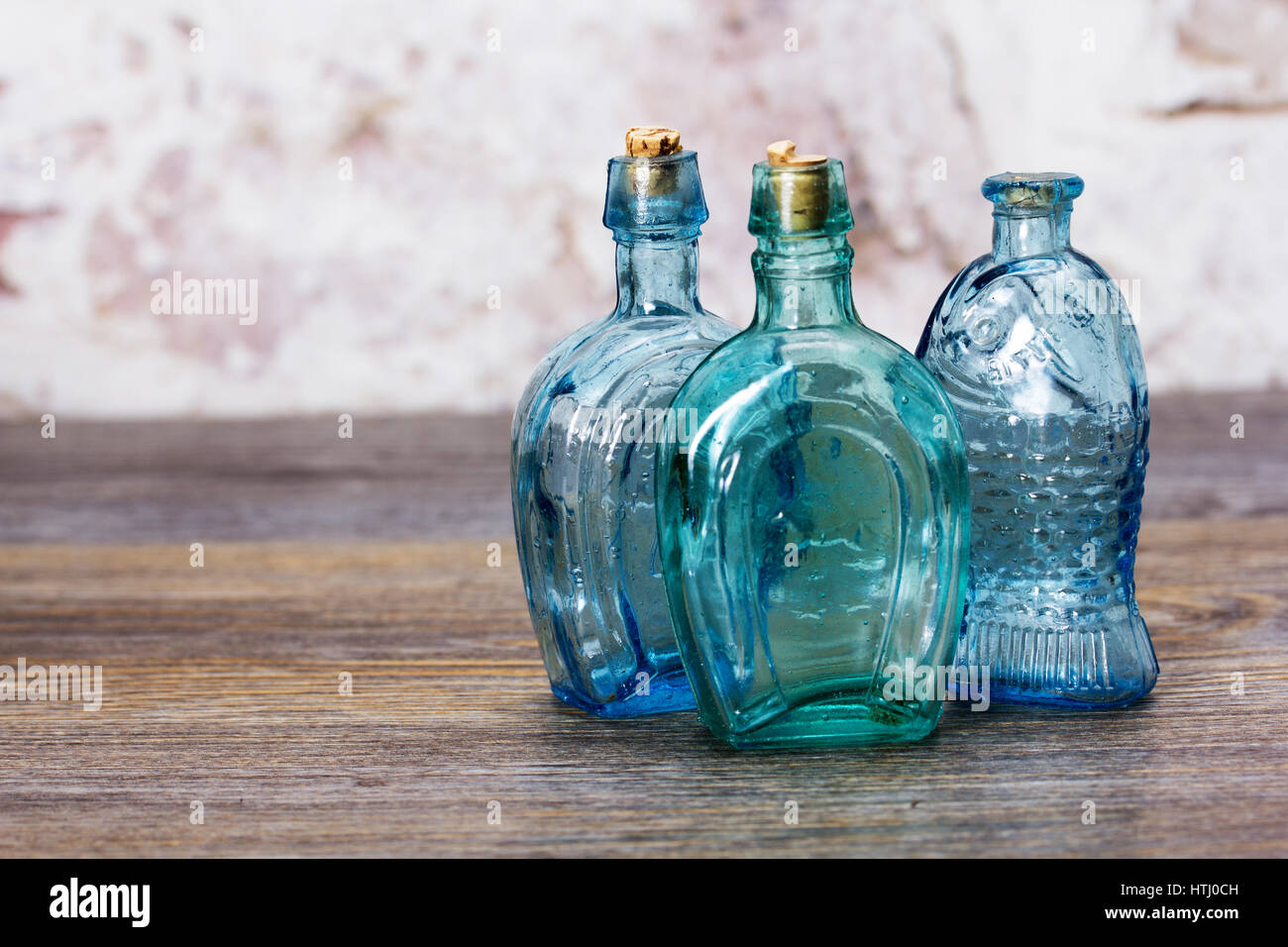 Selection of coloured glass bottles on a rustic background Stock Photo ...