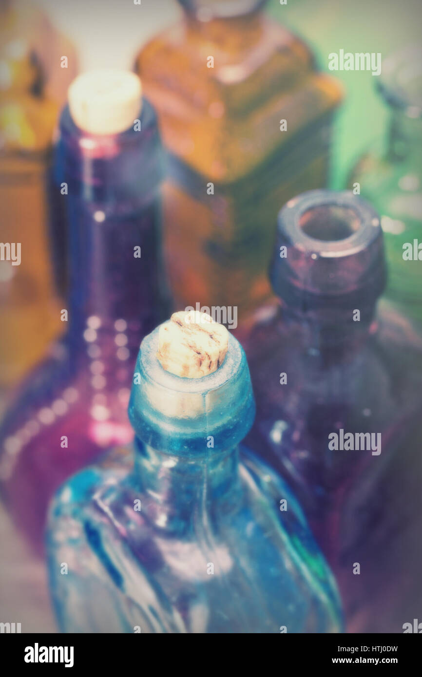 Selection of coloured glass bottles on a rustic background Stock Photo ...