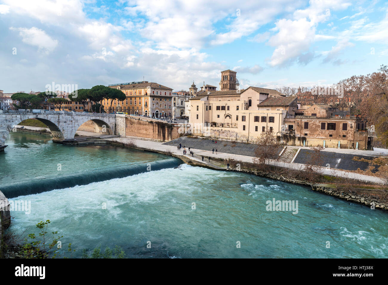 Bridge over the Tiber river passing through Rome with people walking in ...